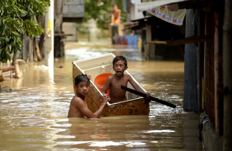 Children Use Boat to Get Around Village During Flooding in the ...